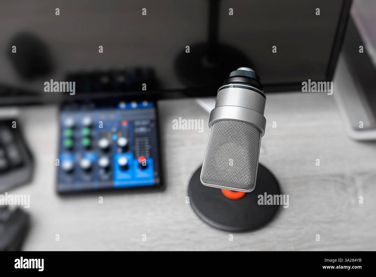 A professional condenser microphone on a desktop stand is set up in a ...