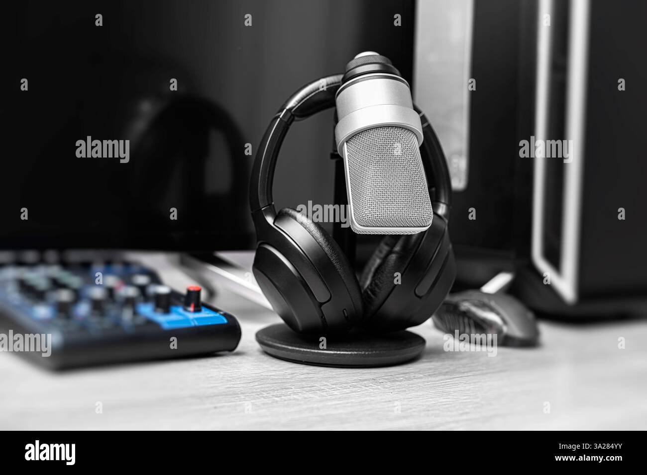 A professional condenser microphone on a desktop stand is set up in a ...