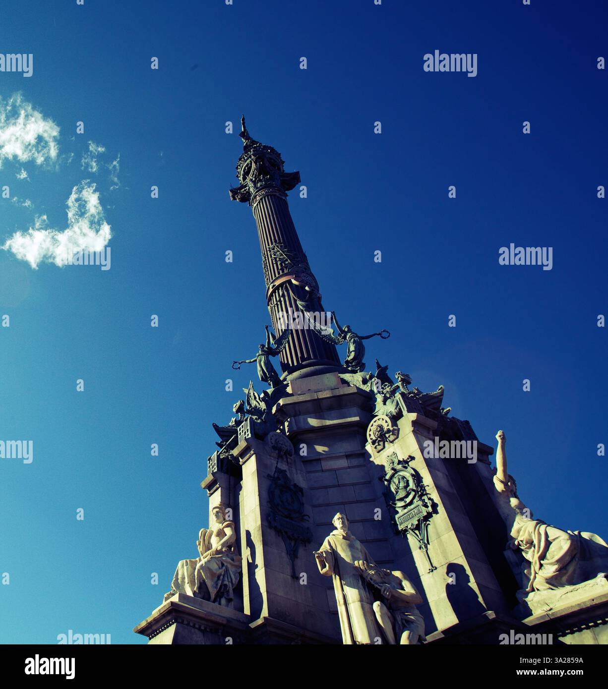 A tall monument featuring intricate sculptures and a clear blue sky ...