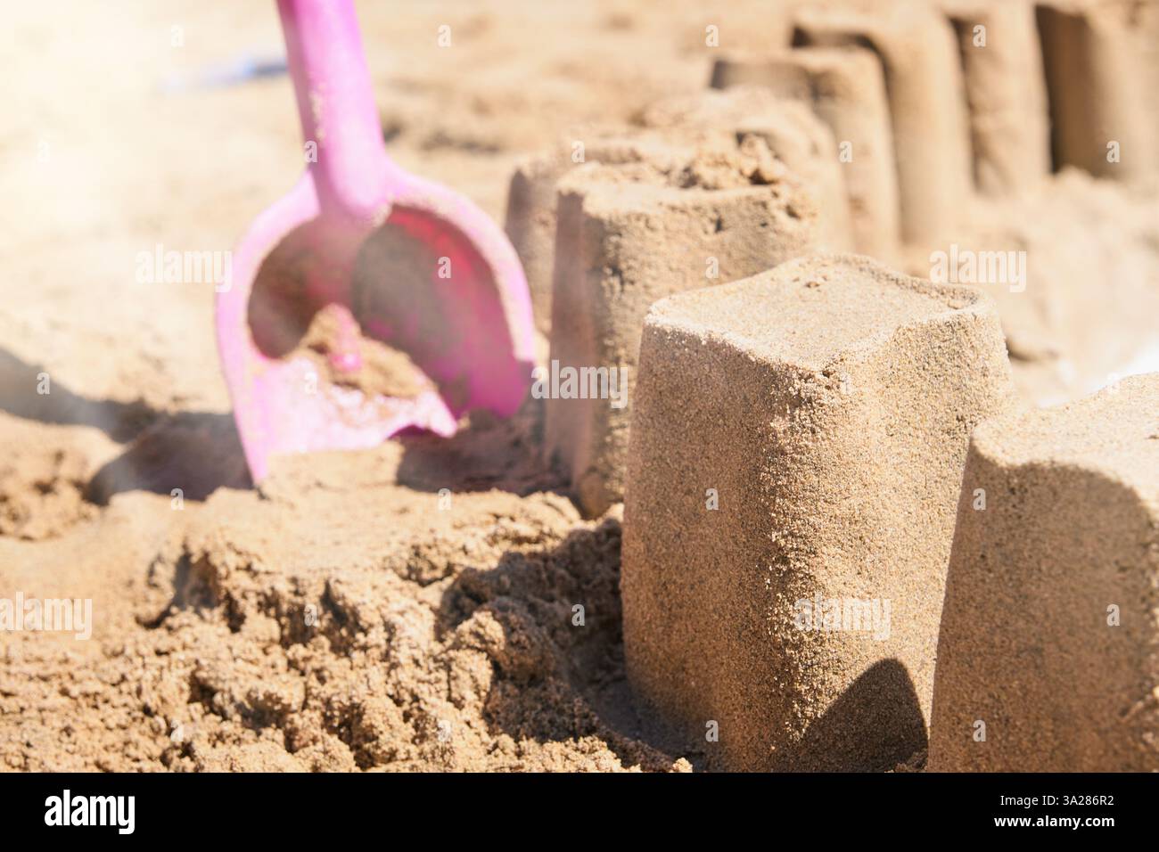 Simple sandcastle on fine sandy beach under the expansive blue sky ...