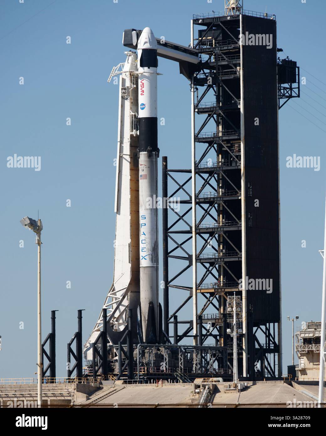 A SpaceX Falcon 9 rocket with the Crew Dragon spacecraft stands ready ...