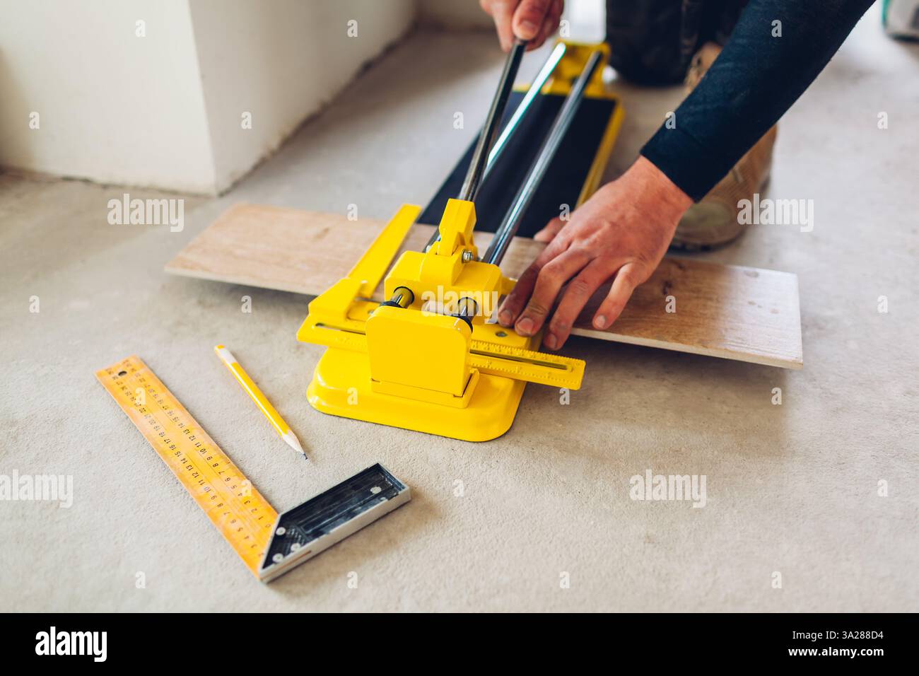 Construction worker using manual cutter equipment for laying processing ...