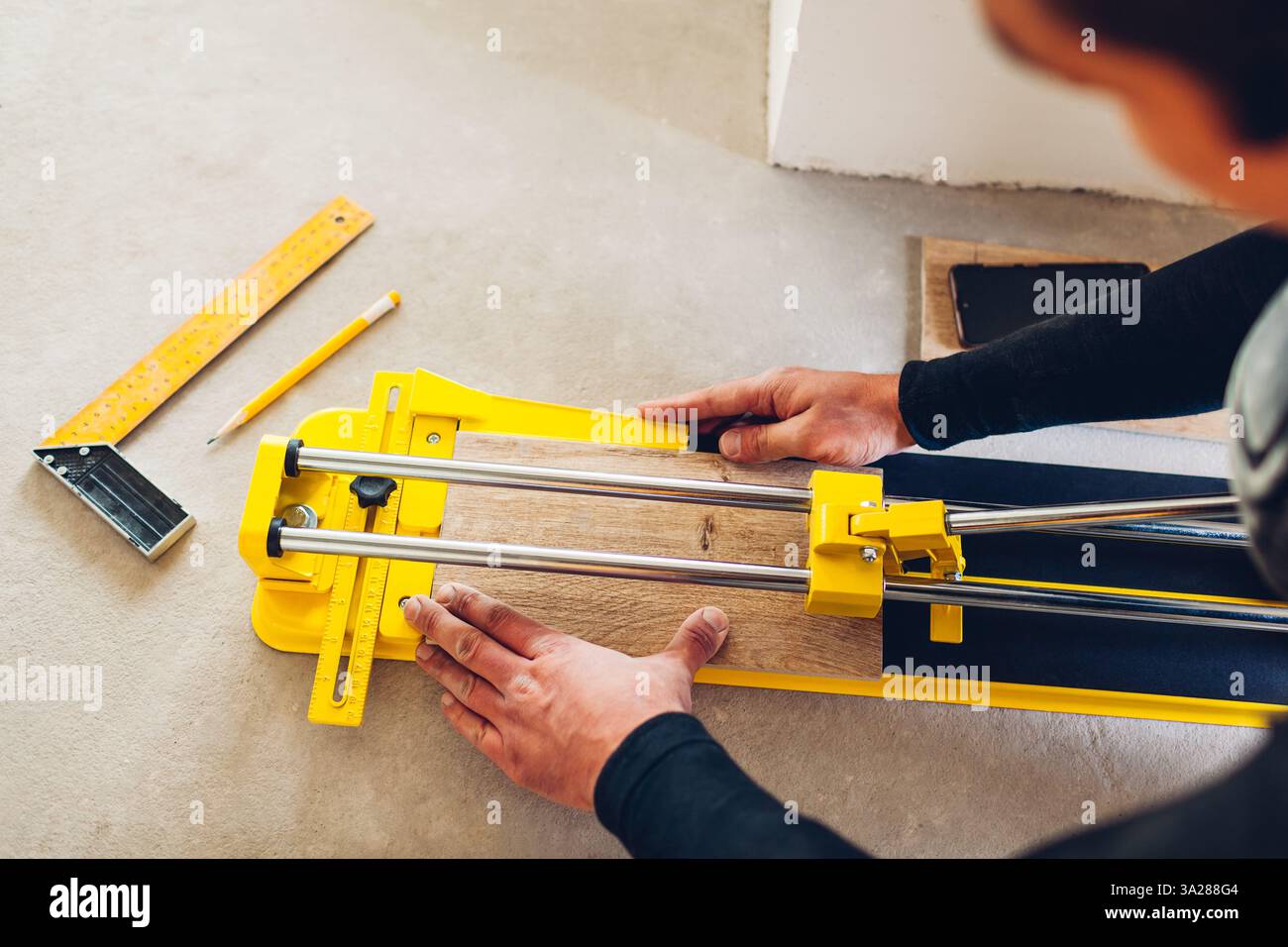 Construction worker using manual cutter equipment for laying processing ...