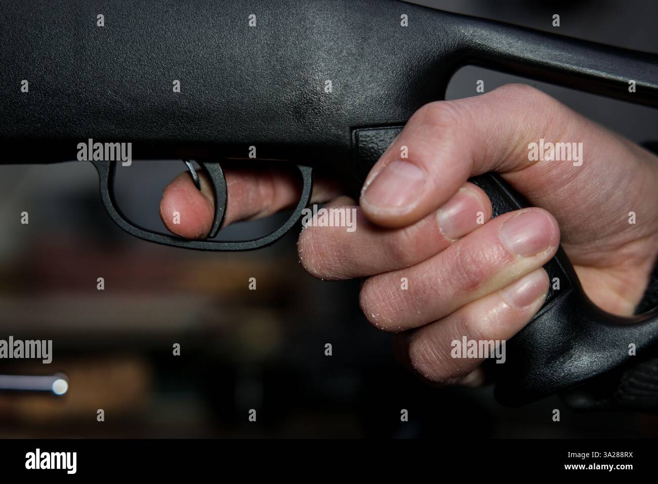 Trigger finger holding gun close up Stock Photo - Alamy