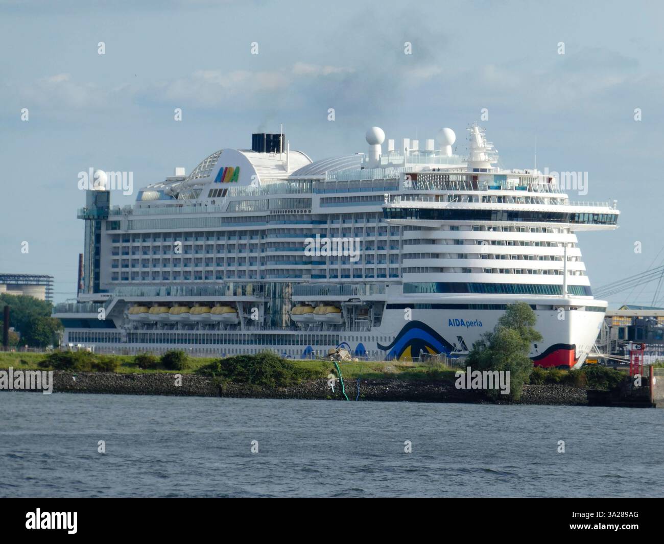 Das Kreuzfahrtschiff AIDA perla liegt an einem Seitearm der Elbe im ...
