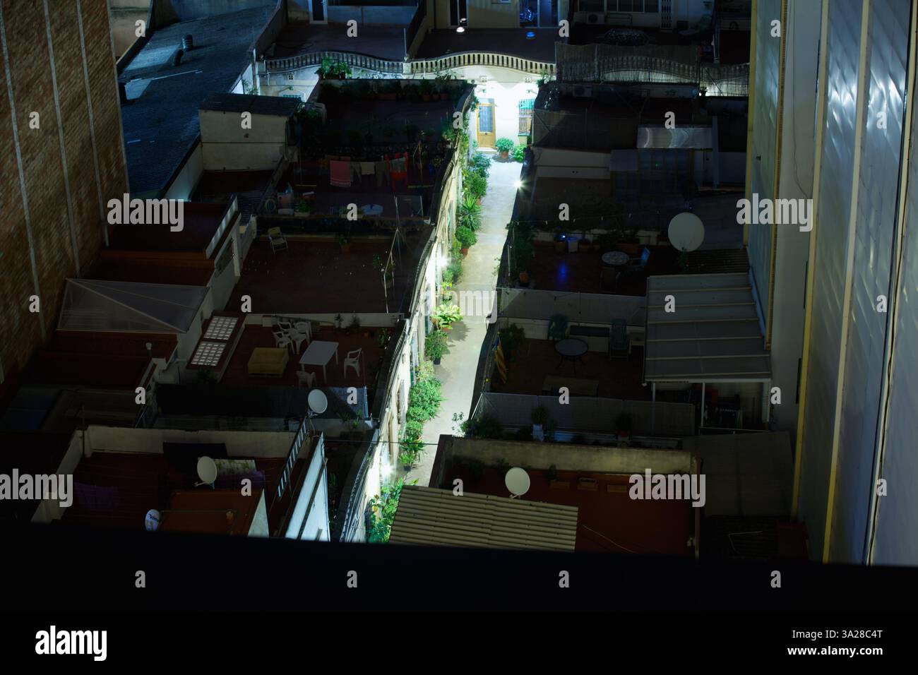 Aerial view of a narrow alleyway between residential buildings at night ...