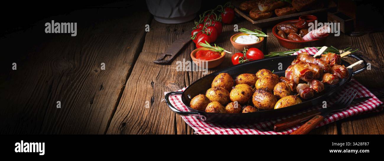 Rustic dates wrapped in bacon and young roasted potato Stock Photo - Alamy