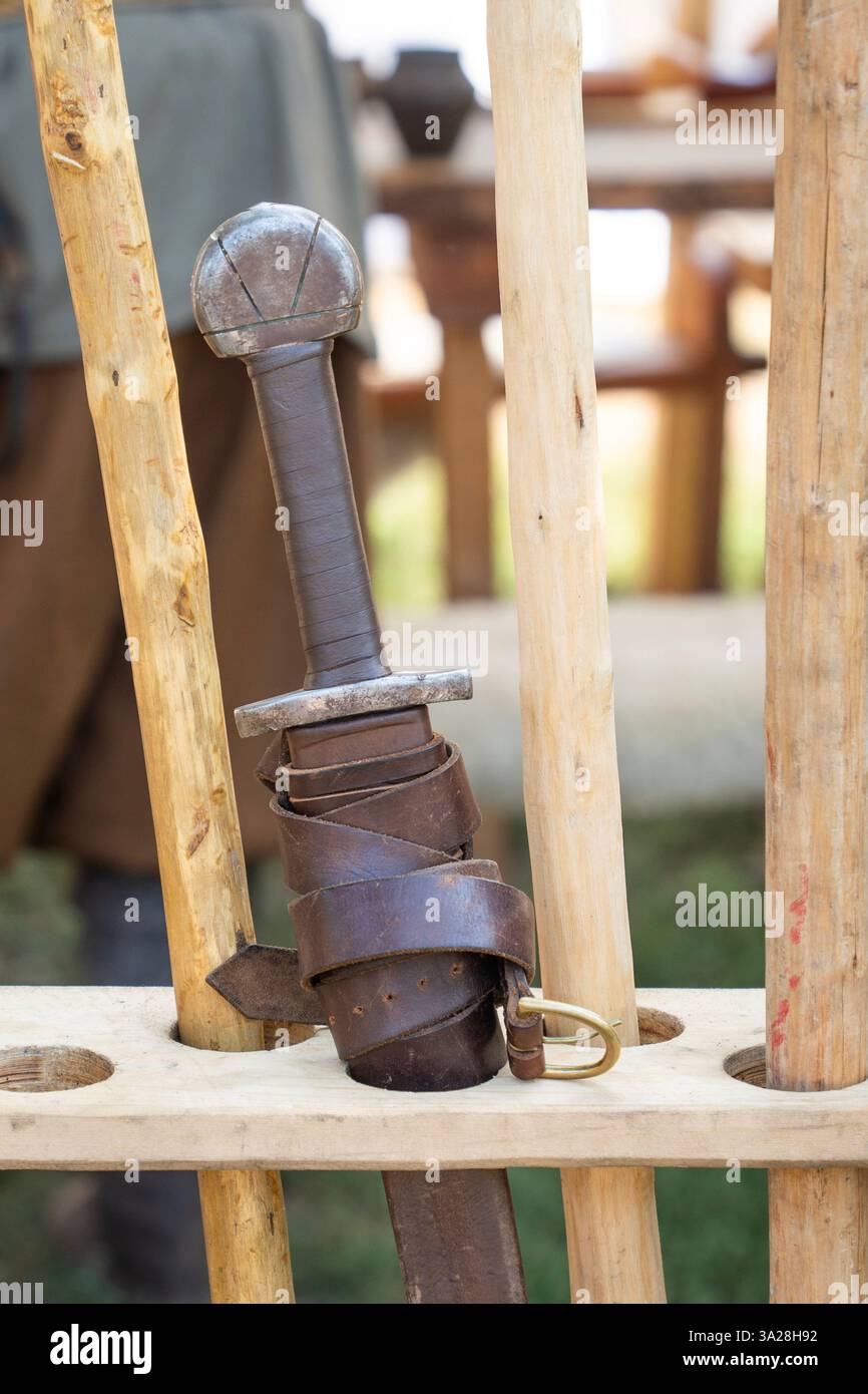 Medieval sword with leather scabbard on wooden rack Stock Photo - Alamy