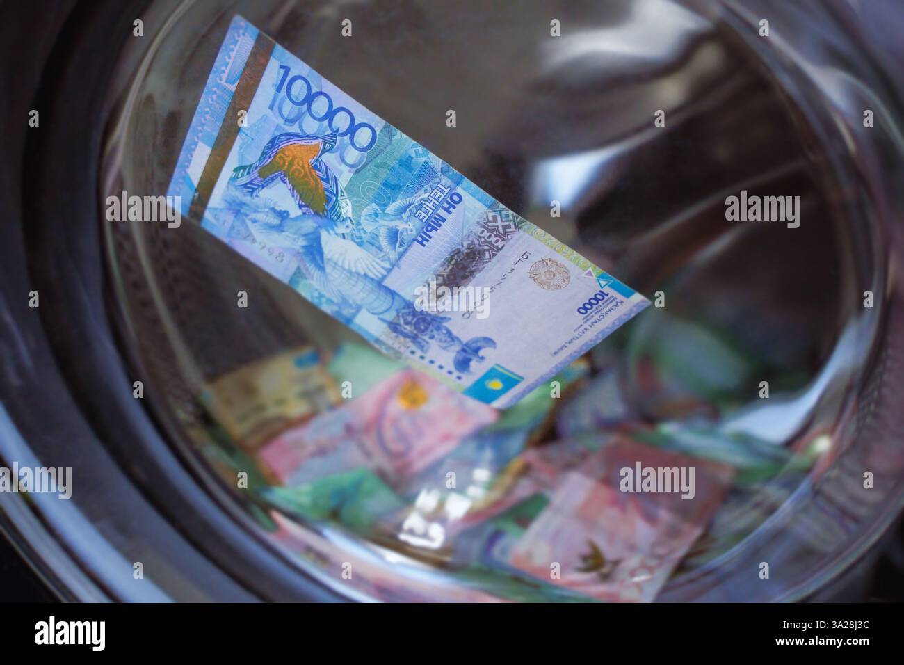 A 10,000 tenge note stuck to the door of a washing machine. Money ...