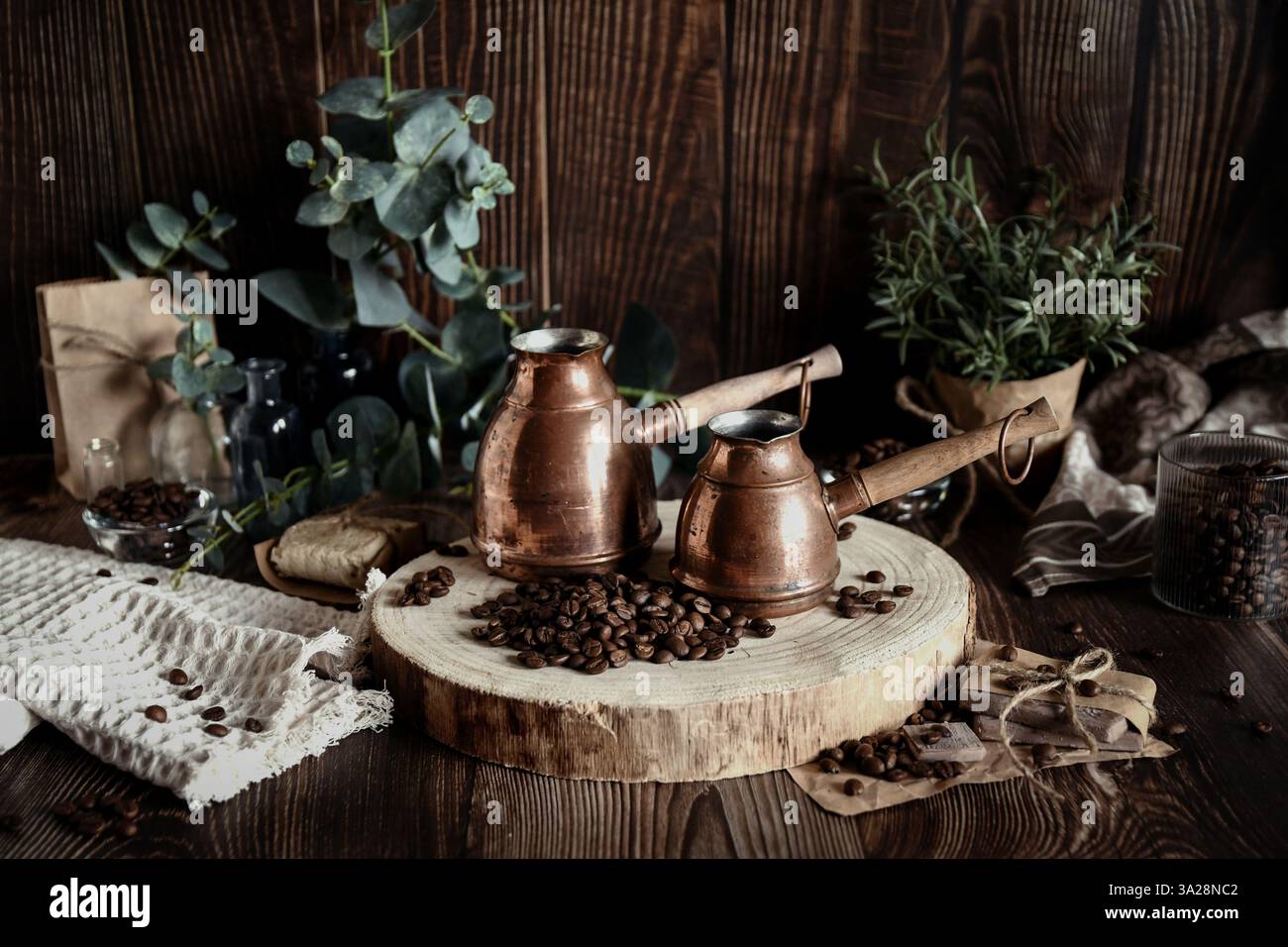 The photograph shows two copper coffee pots standing on a wooden sawn ...