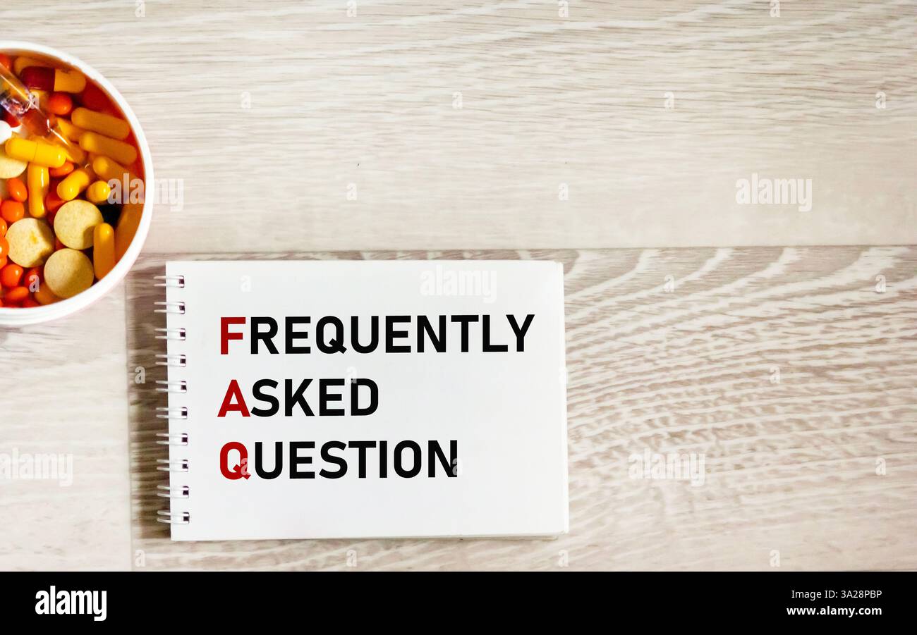 FAQ (Frequently Asked Questions) text on a notepad and a gray ...