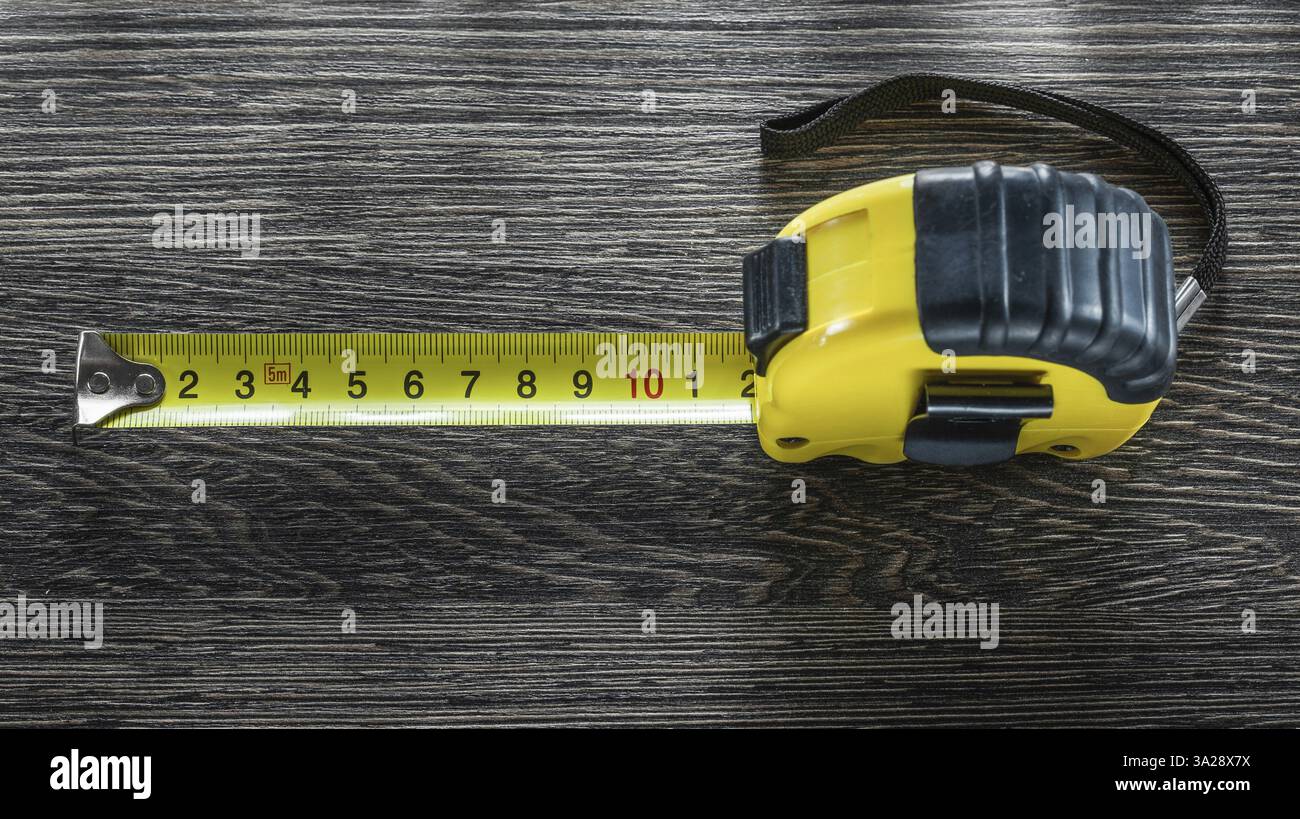 Rolled tapeline on vintage wooden board Stock Photo - Alamy