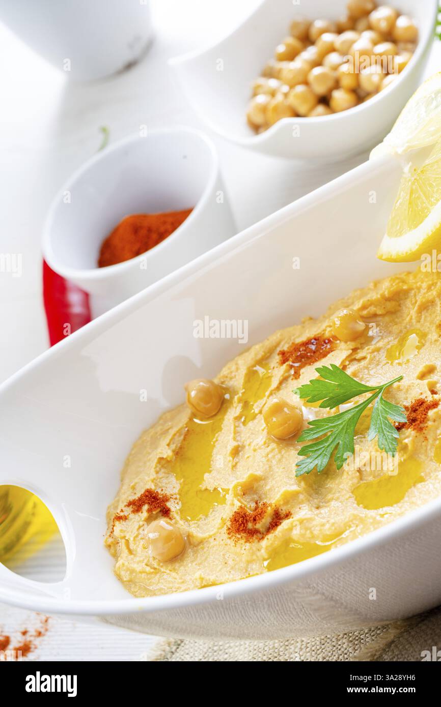 Hummus paste with lemon and chilli on a white background Stock Photo ...