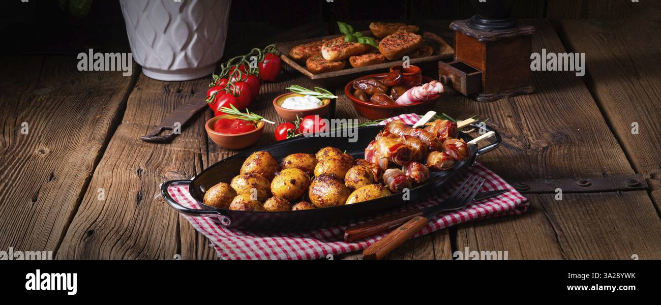 Rustic dates wrapped in bacon and young roasted potato Stock Photo - Alamy