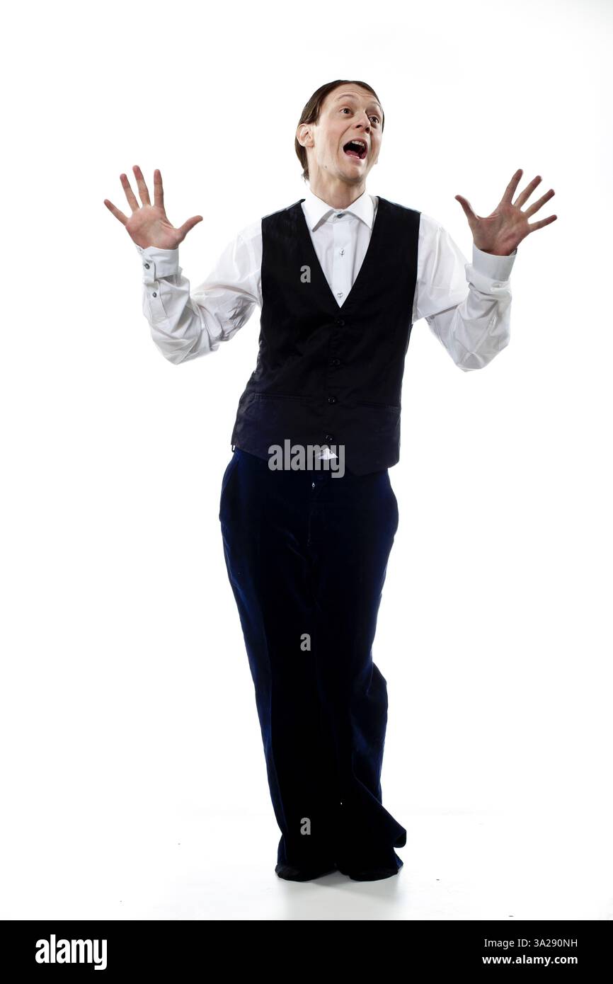 A man in a black vest and white shirt, striking a dramatic pose with ...