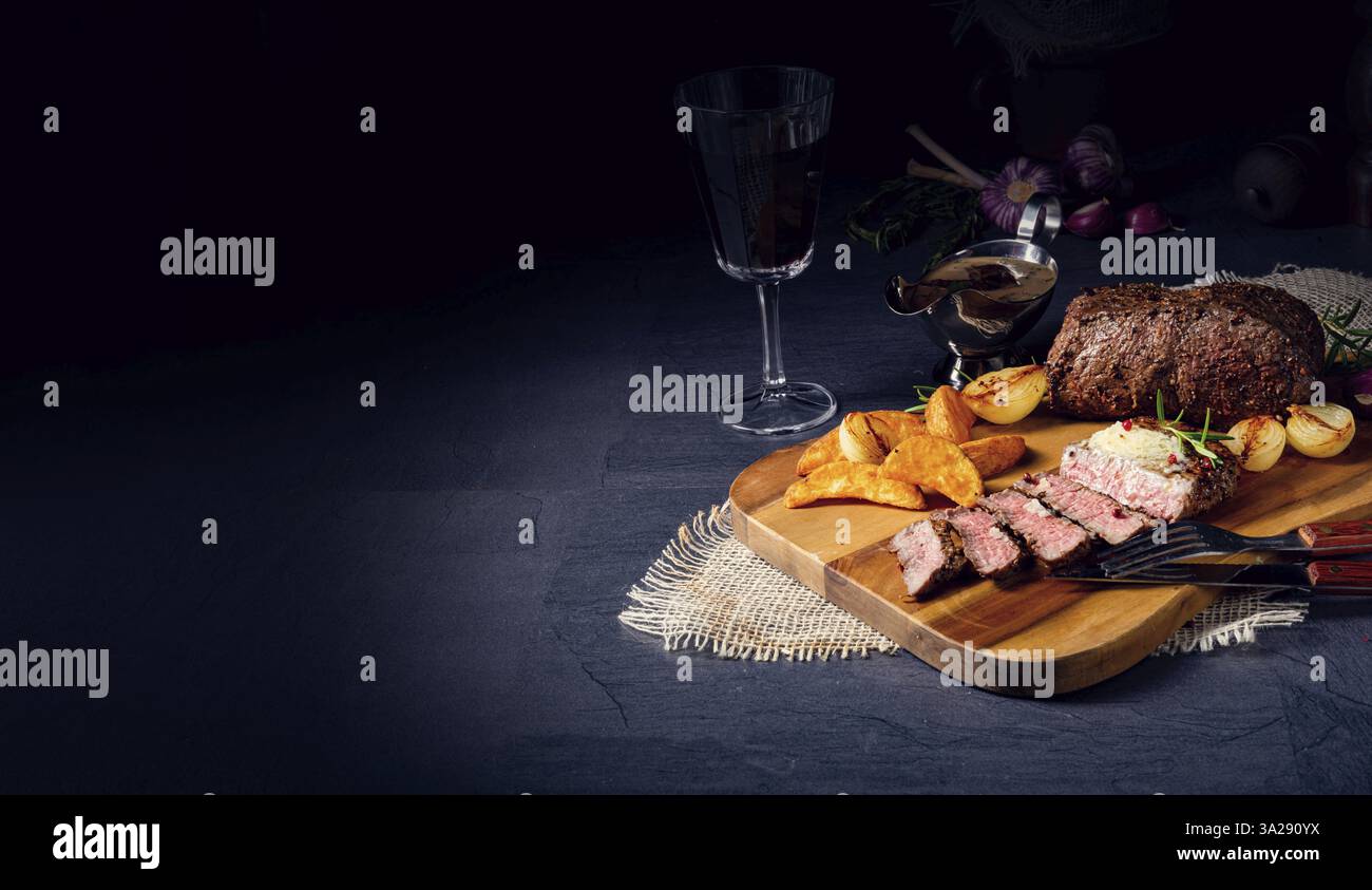 Rustic medium rare beef steak with herbs and potato wedges Stock Photo - Alamy