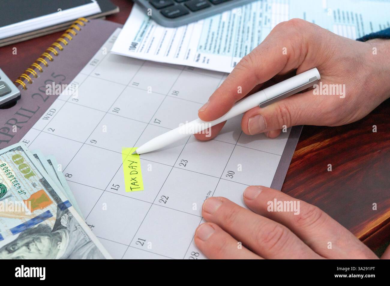 Hand pointing to the day of paying taxes in the United States, next to ...