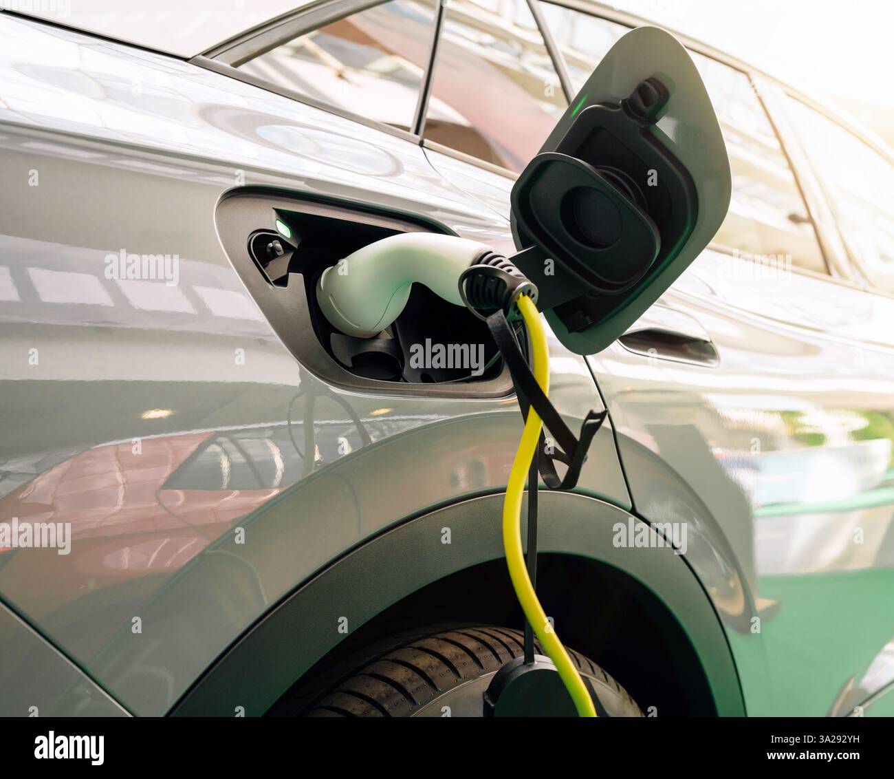 Diagonal view of EV charging plug inserted into electric car Stock ...