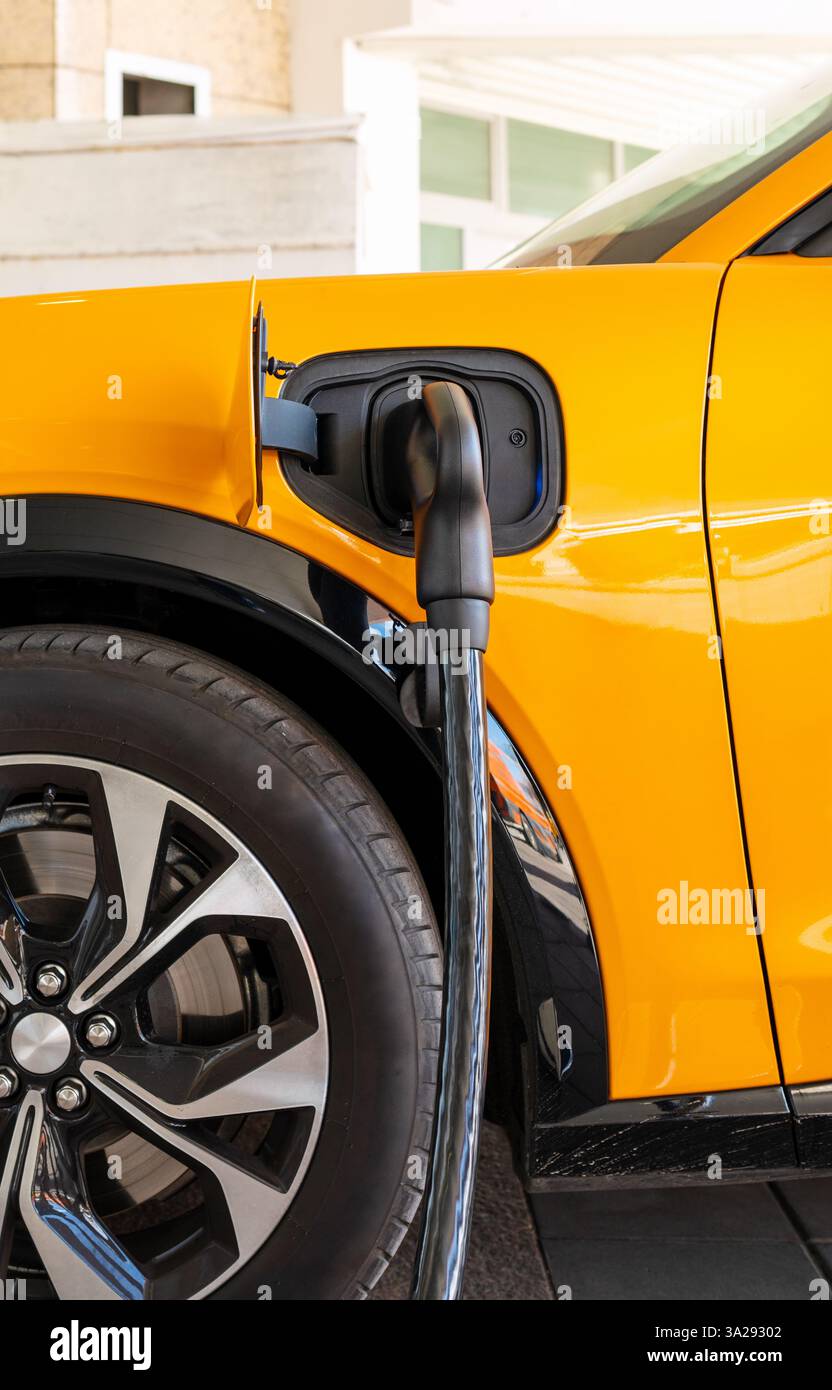 Fast EV charging station. Close-up of EV charging plug inserted into ...