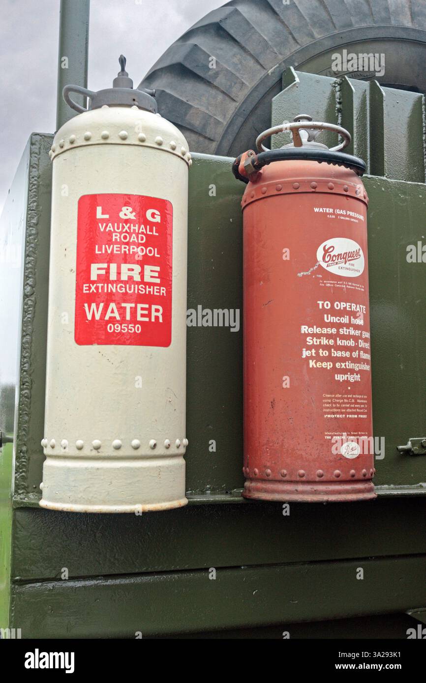A pair of old fire extinguishers on the rear of a military vehicle ...
