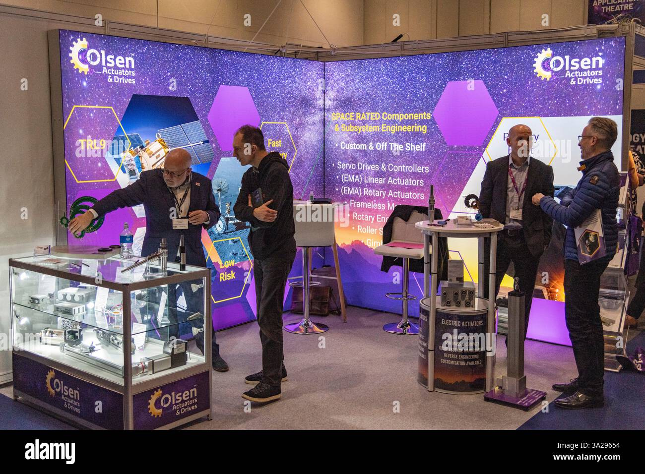 People talking at an Olsen stall exhibit at the Space Comm Expo 2025 at ...