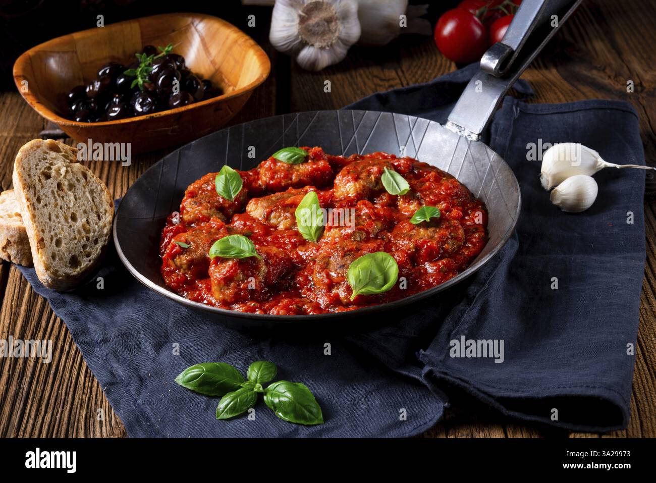 Baked mini balls in tomato sauce with basil Stock Photo - Alamy