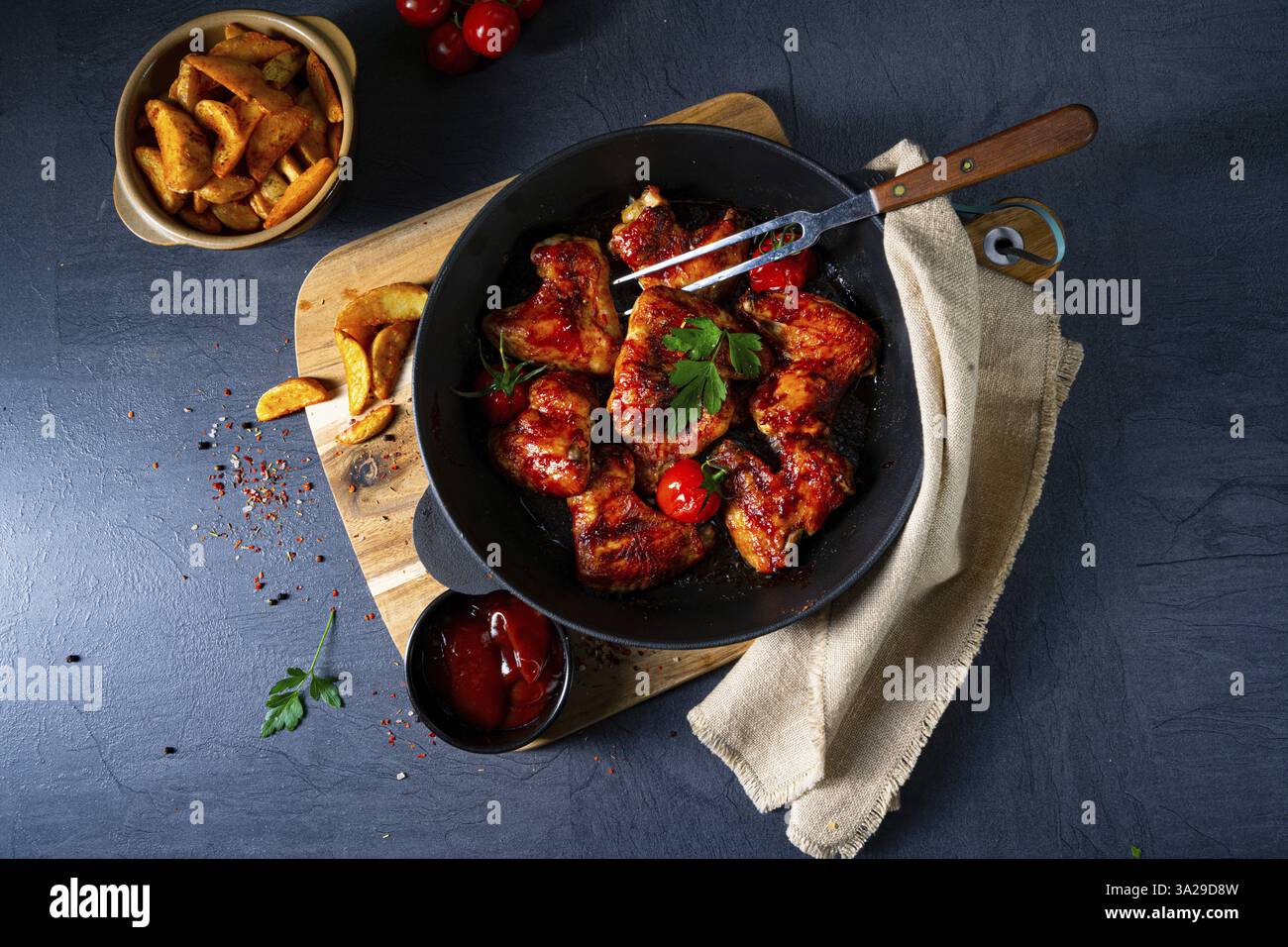 Savoury chicken wings in honey with potato wedges Stock Photo - Alamy