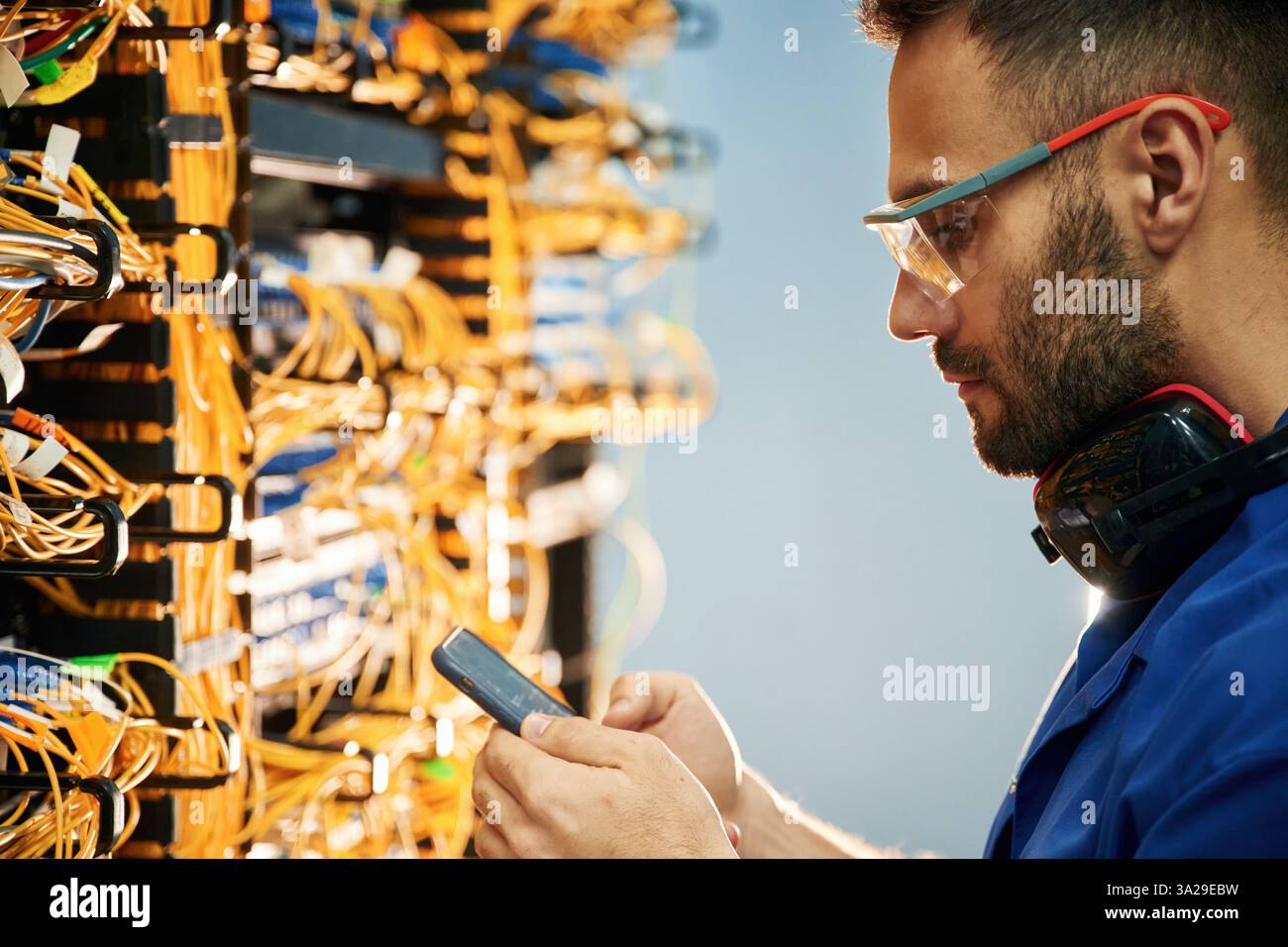 Holding smartphone. Young man is working with internet equipment and ...