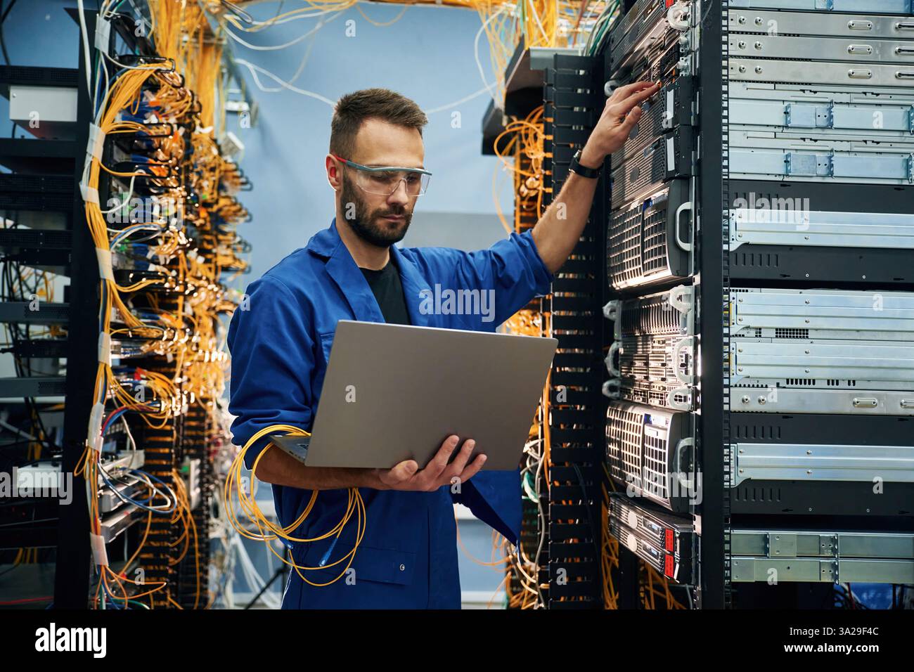 Using the laptop. Young man is working with internet equipment and ...