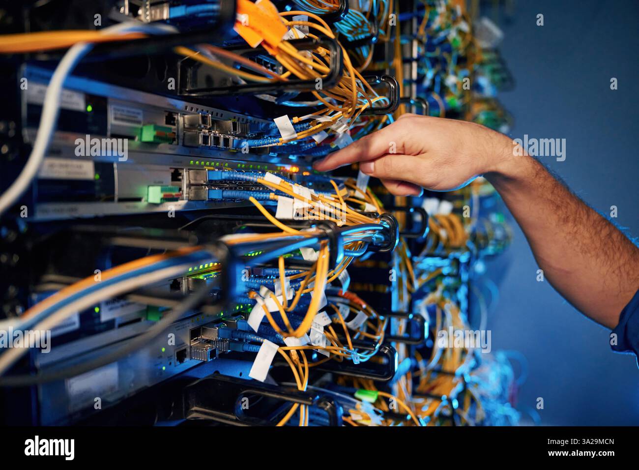 Cables management. Young man is working with internet equipment and ...