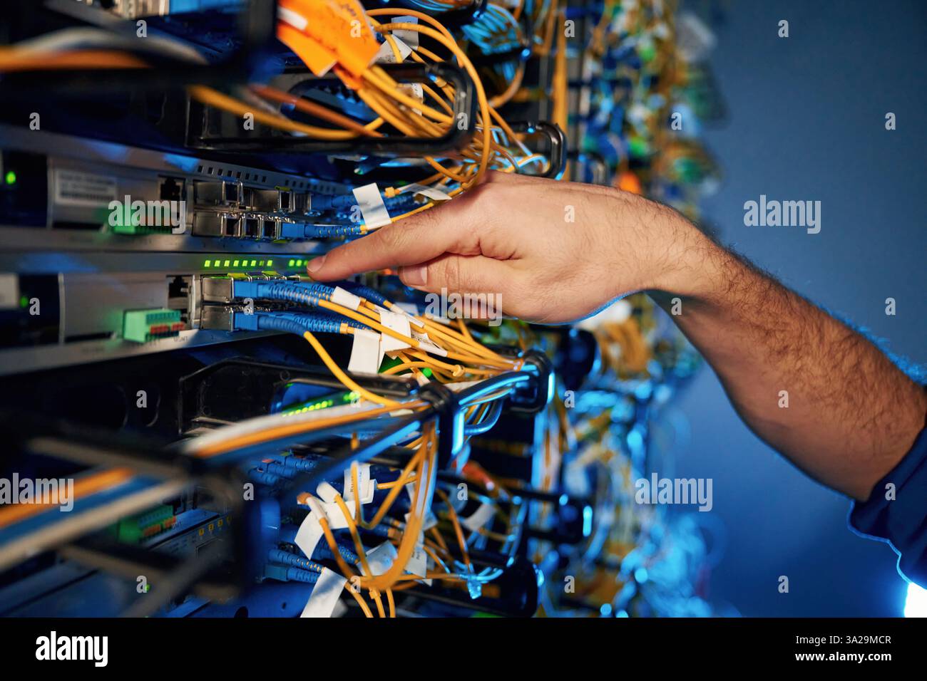 Cables management. Young man is working with internet equipment and ...