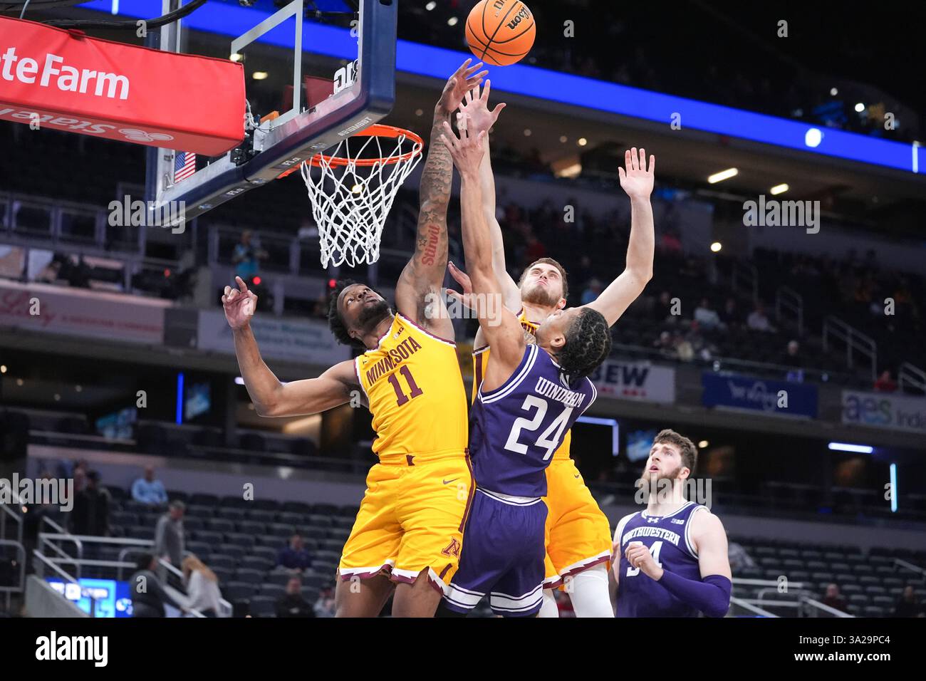 Minnesota guard Femi Odukale (11) blocks a Northwestern guard K.J ...