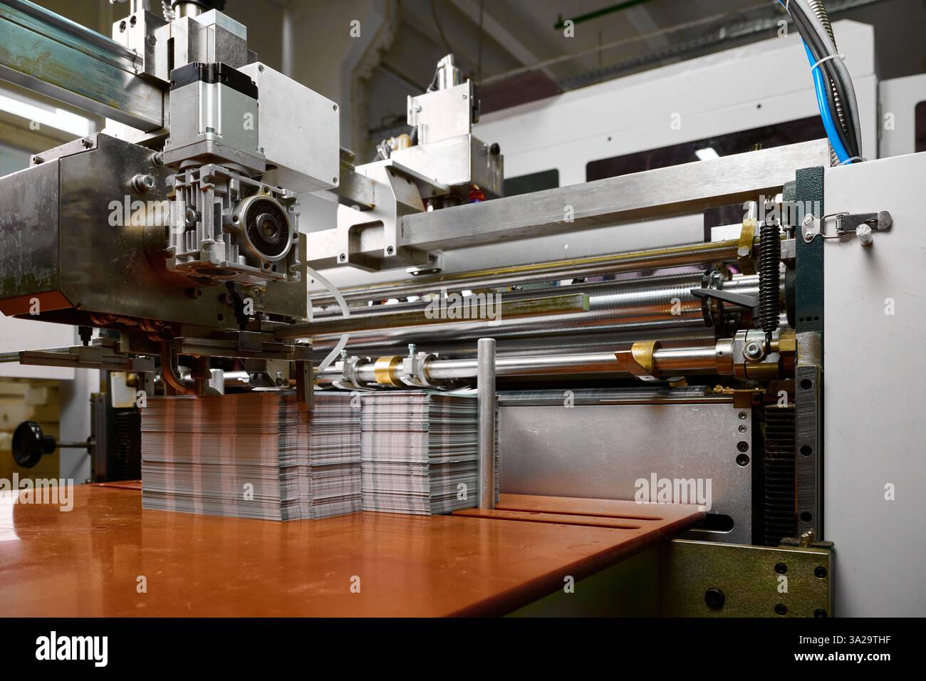 Glue spreading machine operates efficiently as paper feeds through for ...