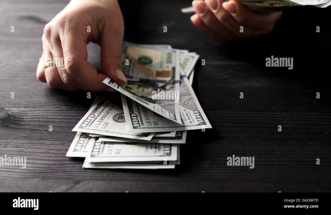 Lady Calculating Her Money Savings In Us Dollar Bills Stock Photo - Alamy