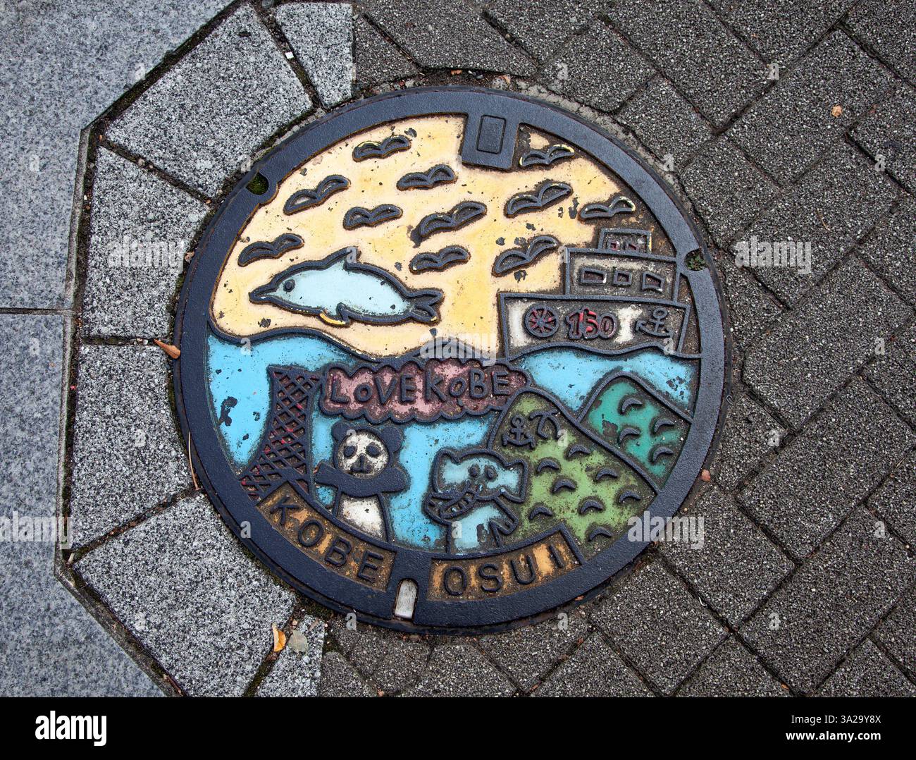A Kobe Osui Manhole Cover on a sidewalk in Kobe City, Japan. Many ...