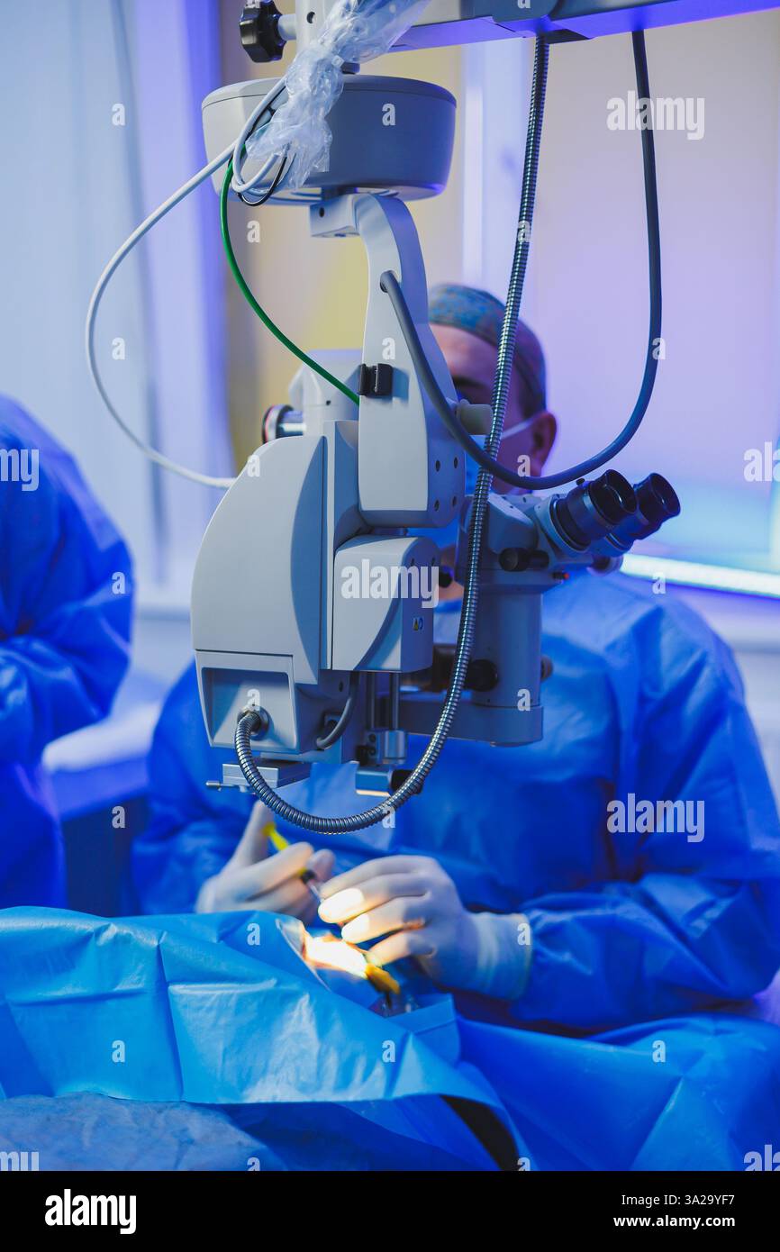 Man under a surgical microscope for vision correction. Eye surgery. A ...
