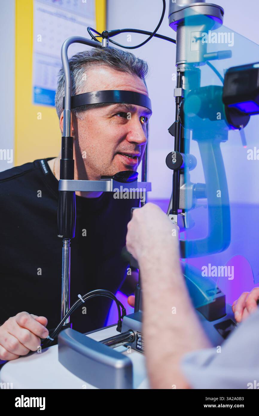 Checking a man's vision with a modern microscope at an appointment with ...