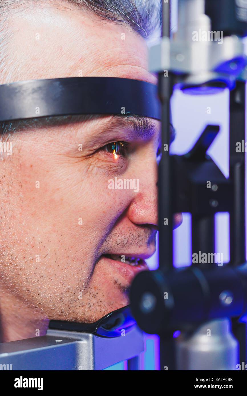 Checking a man's vision with a modern microscope at an appointment with ...