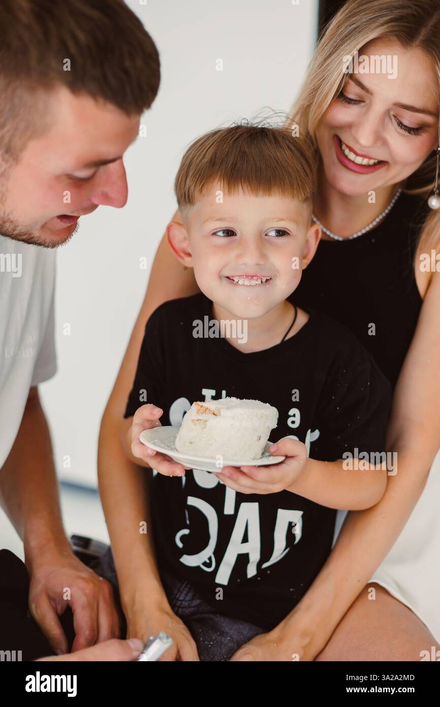 A joyful family moment captured, featuring a child holding a cake ...