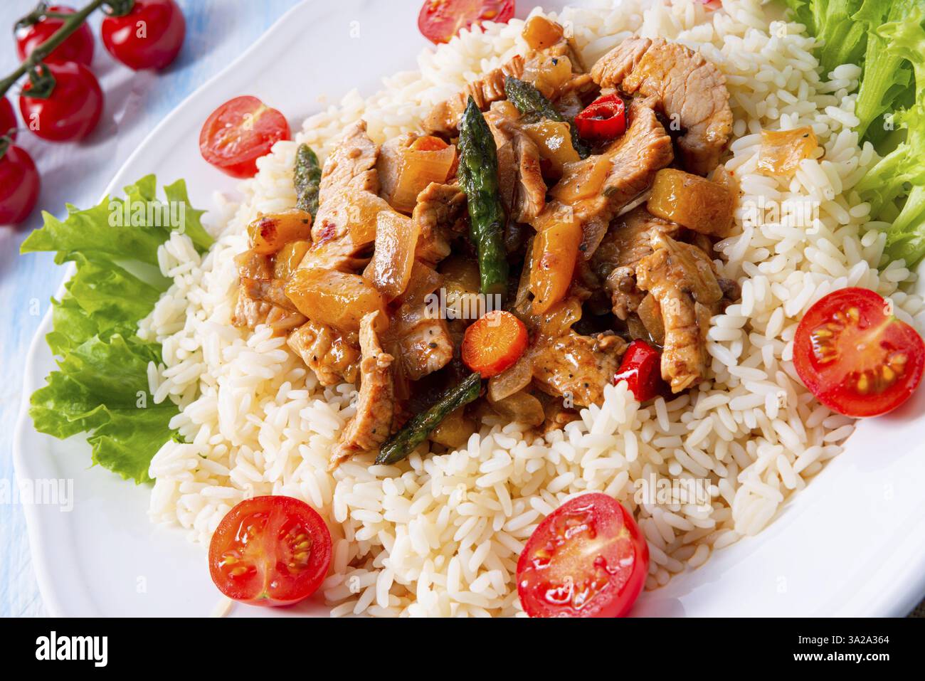 Turkey fricassee on rice with asparagus and peppers Stock Photo - Alamy