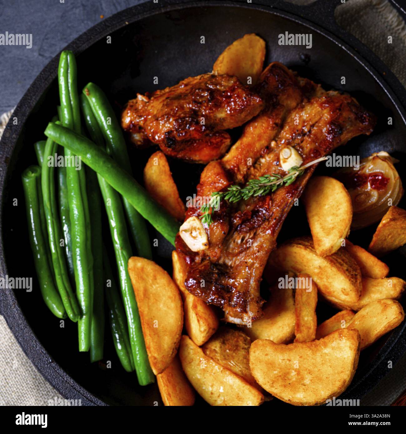 Pork with beans and quarter potatoes Stock Photo - Alamy