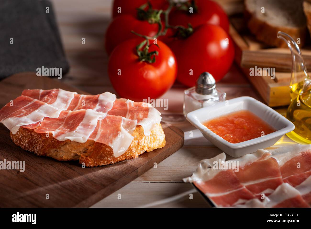 Toasted bread with ham, olive oil, and tomato, accompanied by its ...