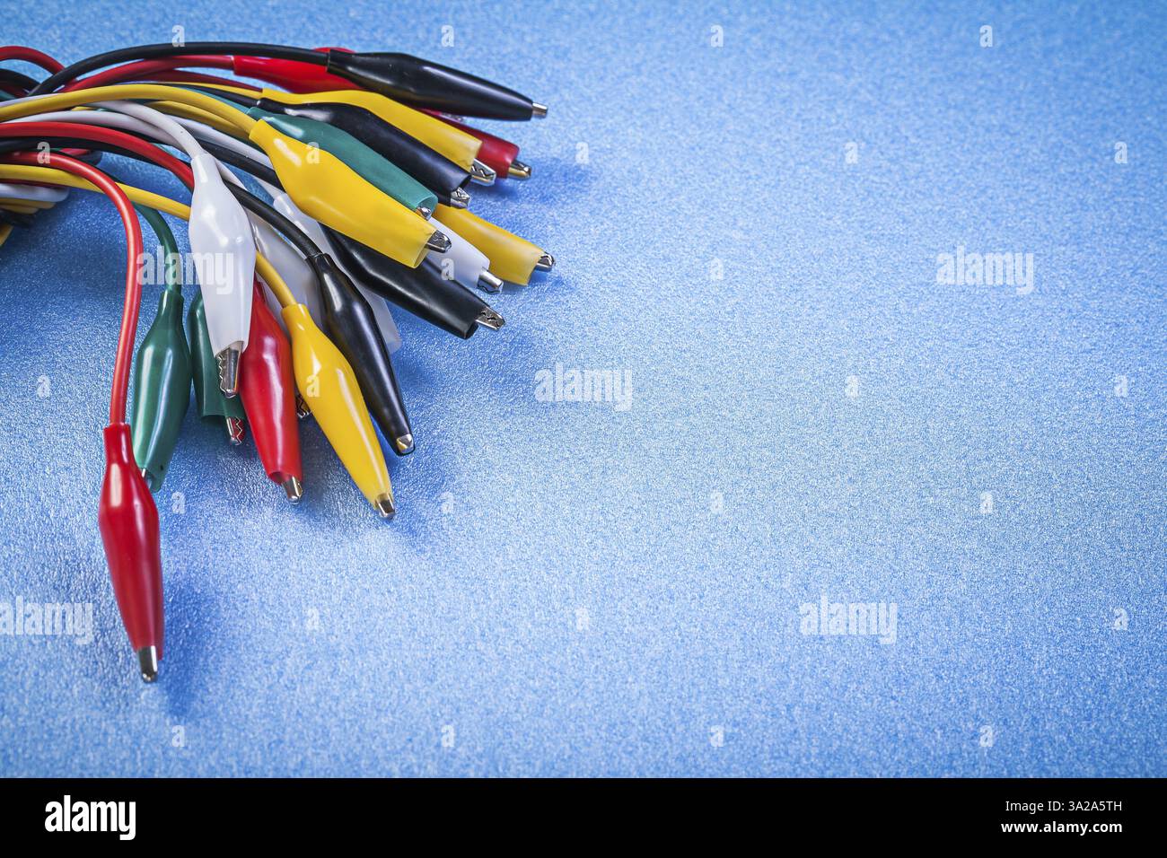 Set of multicolored electric crocodile plugs on blue background Stock ...