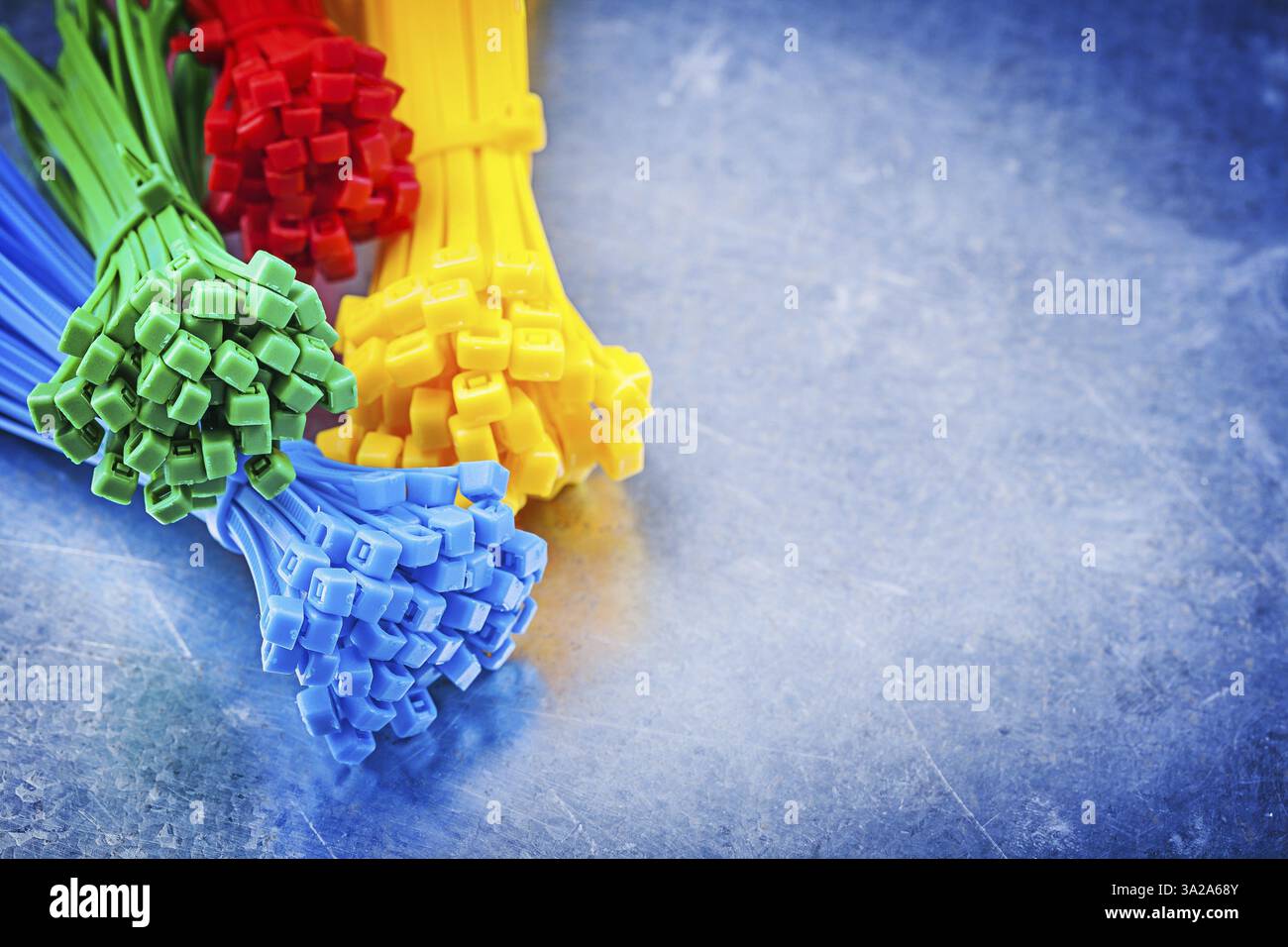 Set of multicolored plastic tying cables on scratched metallic ...