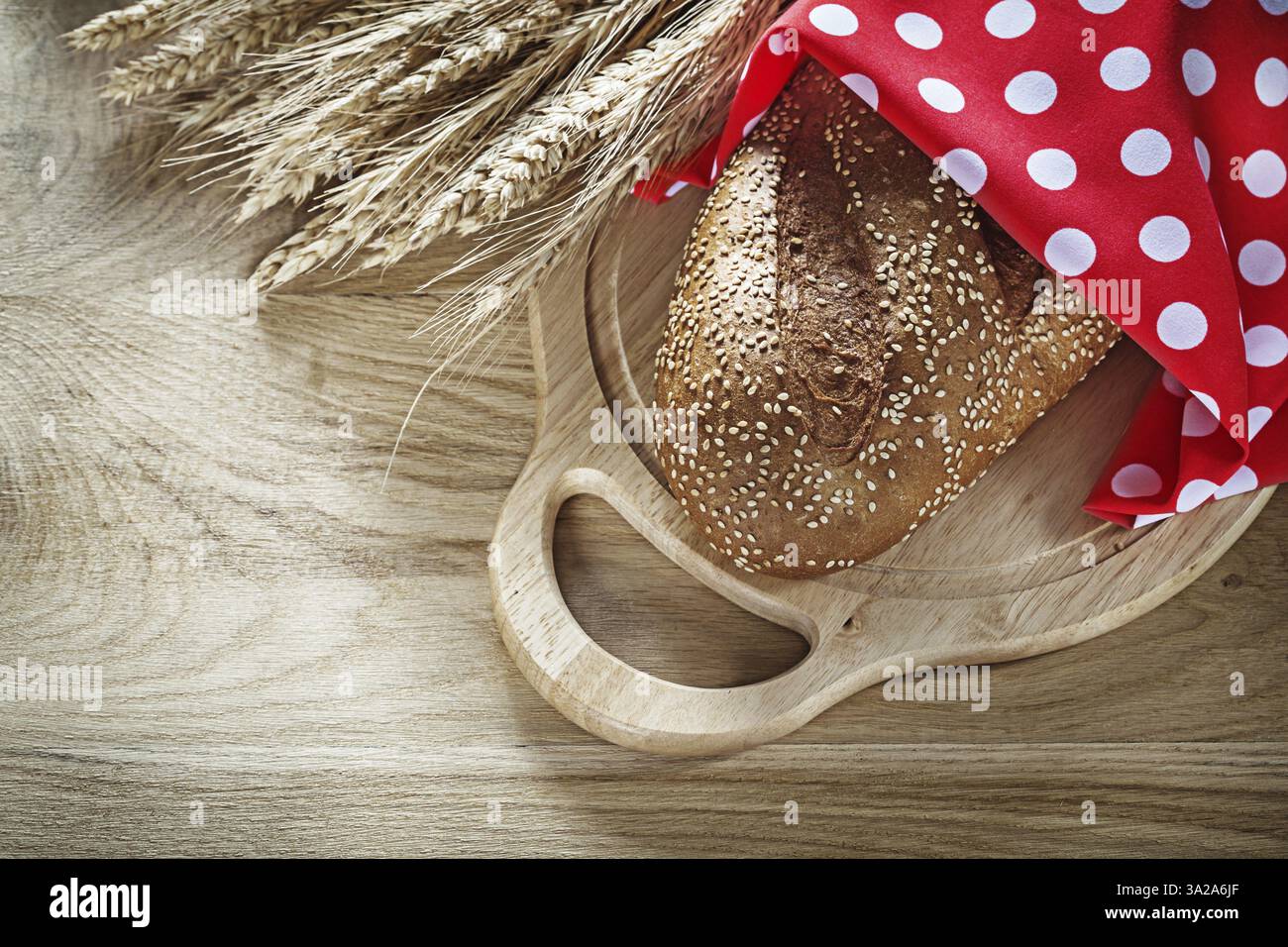 Set of bread rye ears red polka-dot napkin chopping board on wooden background Stock Photo - Alamy