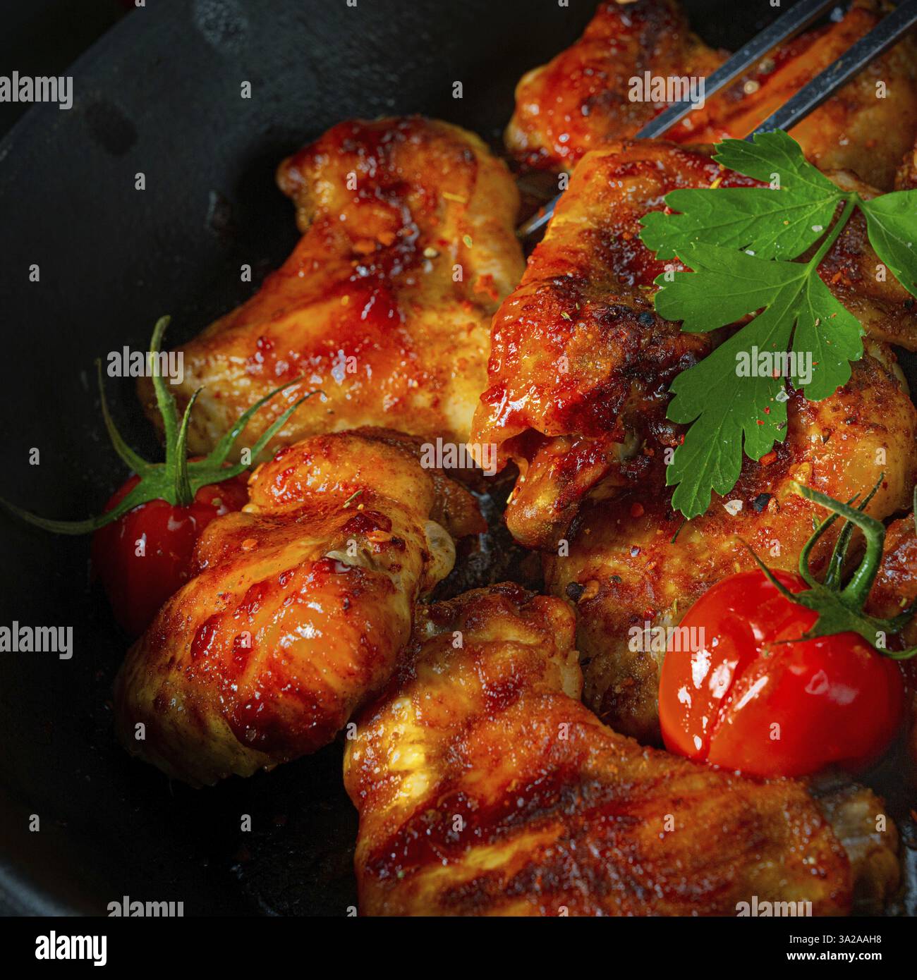 Savoury chicken wings in honey with potato wedges Stock Photo - Alamy