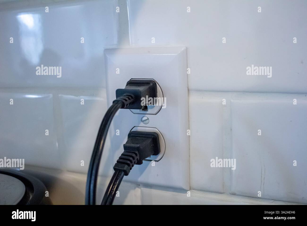 A view of two plugs that are plugged into a electrical socket Stock ...