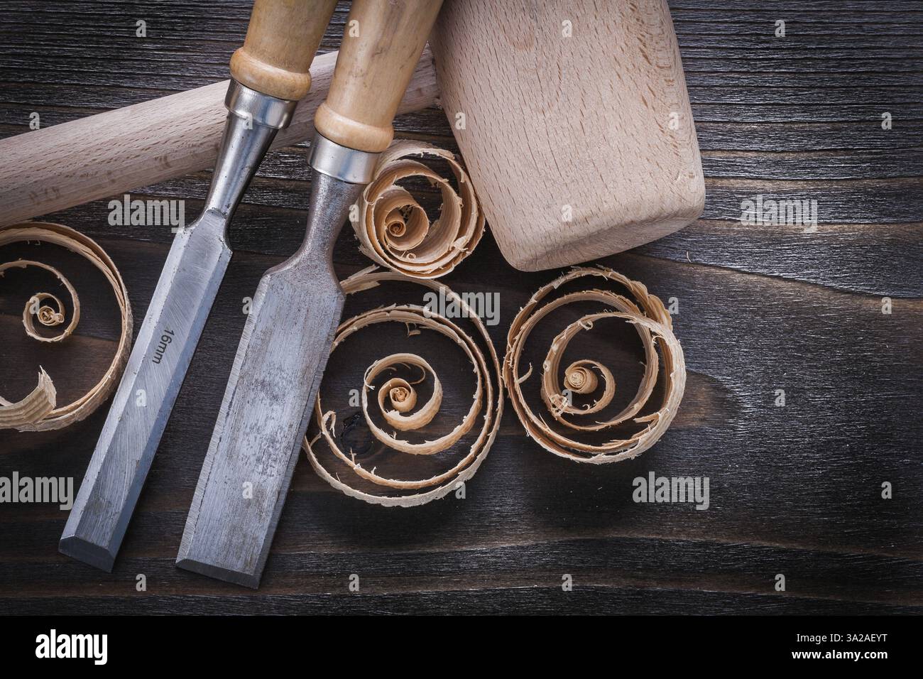 Set of wooden hammer firmer chisels and curled up shavings on vintage ...