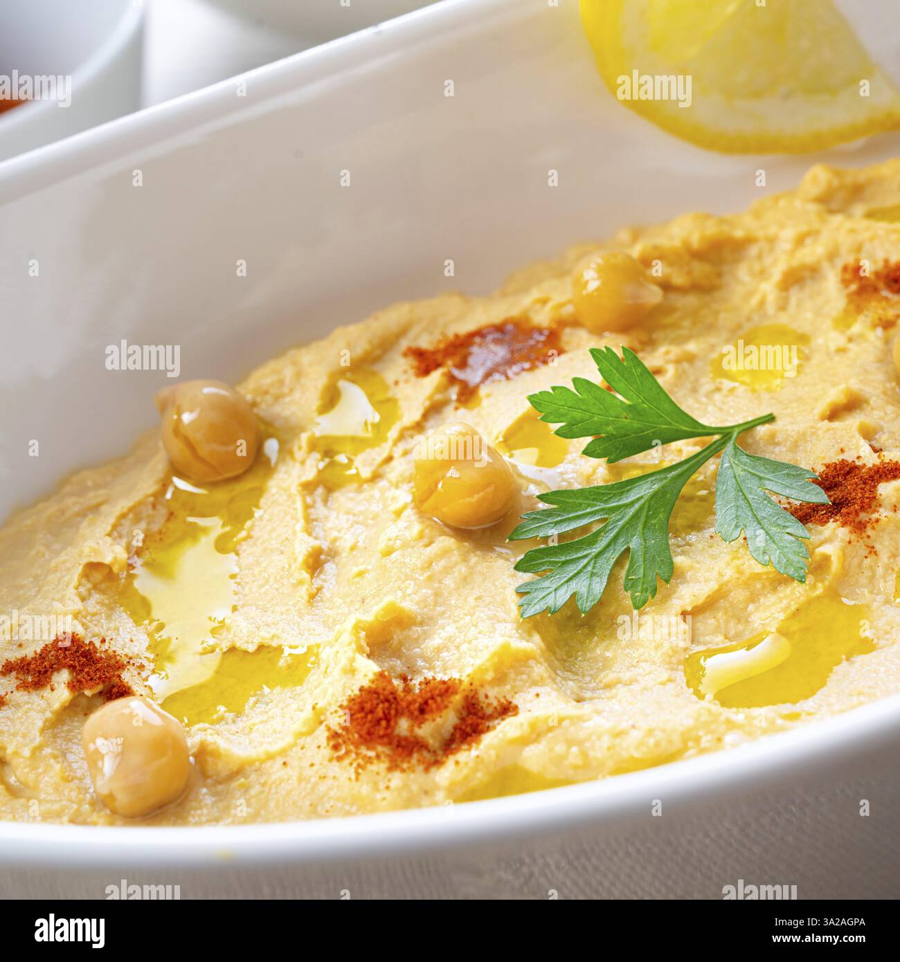 Hummus paste with lemon and chilli on a white background Stock Photo ...