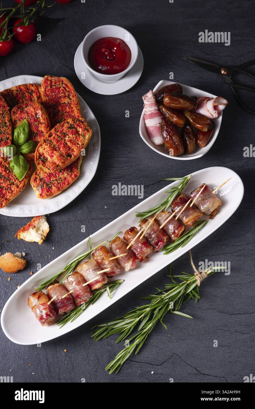 Dates wrapped in bacon and delicious tapas Stock Photo - Alamy